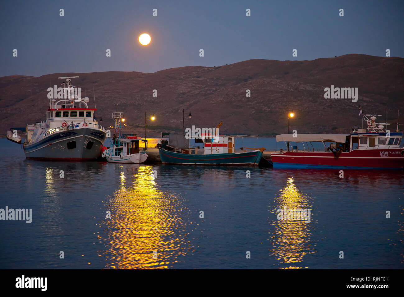 Fishing boats at dawn with a full moonset Stock Photo - Alamy