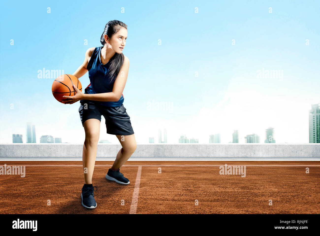 Beautiful asian basketball player woman with ball on her hands on the ...