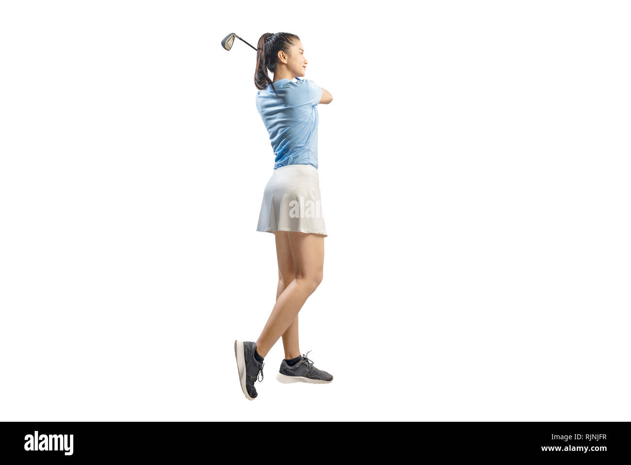 Young asian female gazing the golf ball after hit the ball with iron ...
