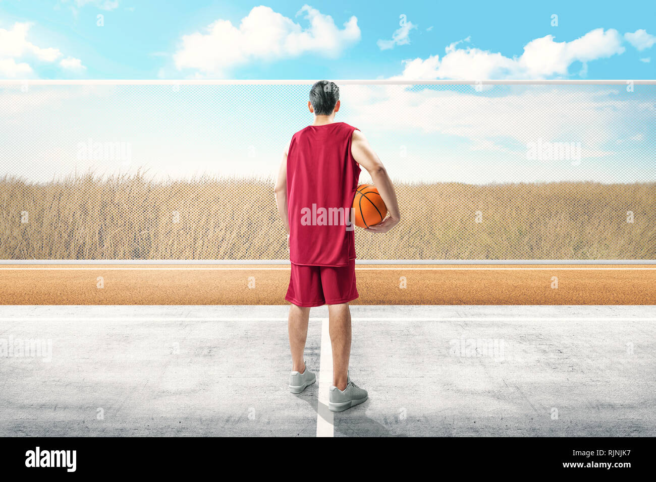 Back view of asian basketball player man standing with ball on his hand ...
