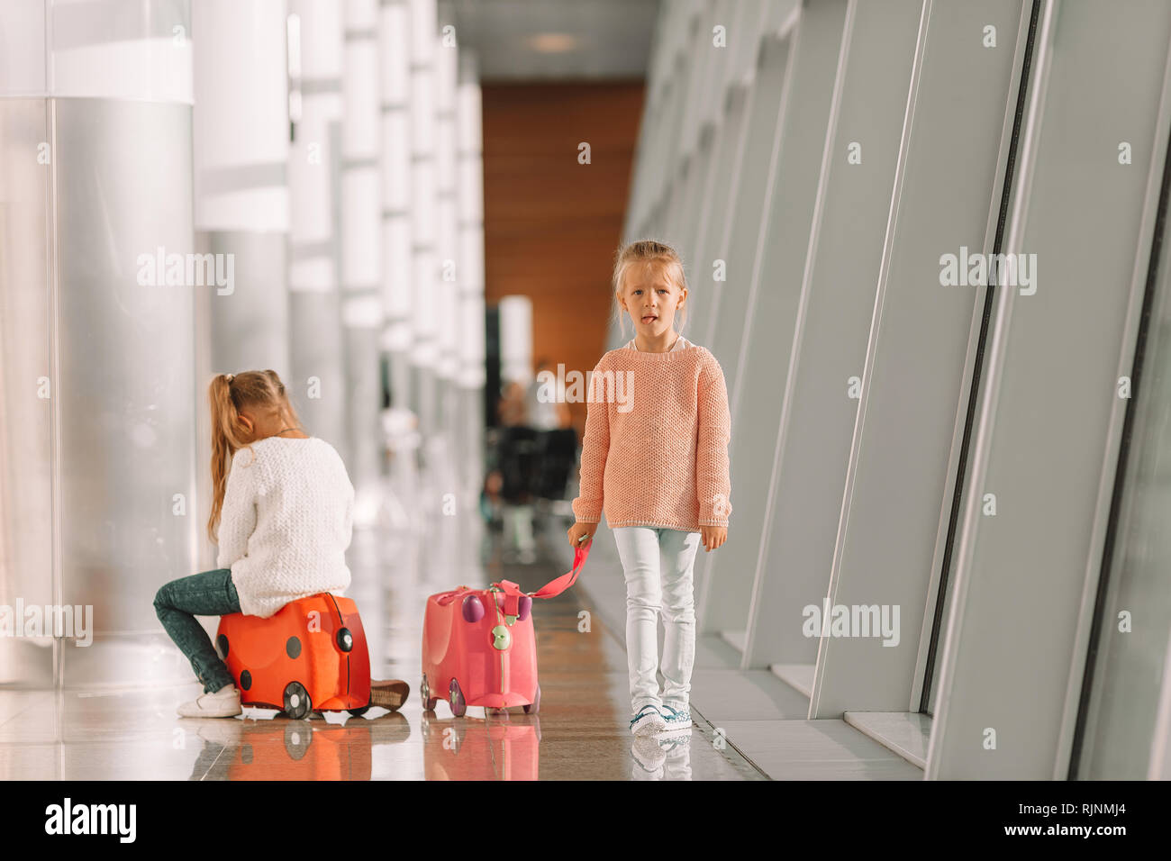 Adorable little girl in big international airport ready for vacation ...