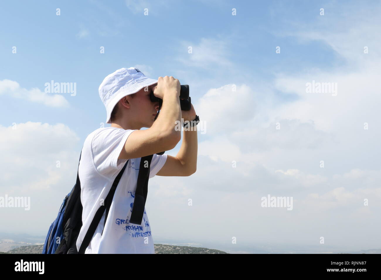 A person looking into the distance using binoculars Stock Photo - Alamy