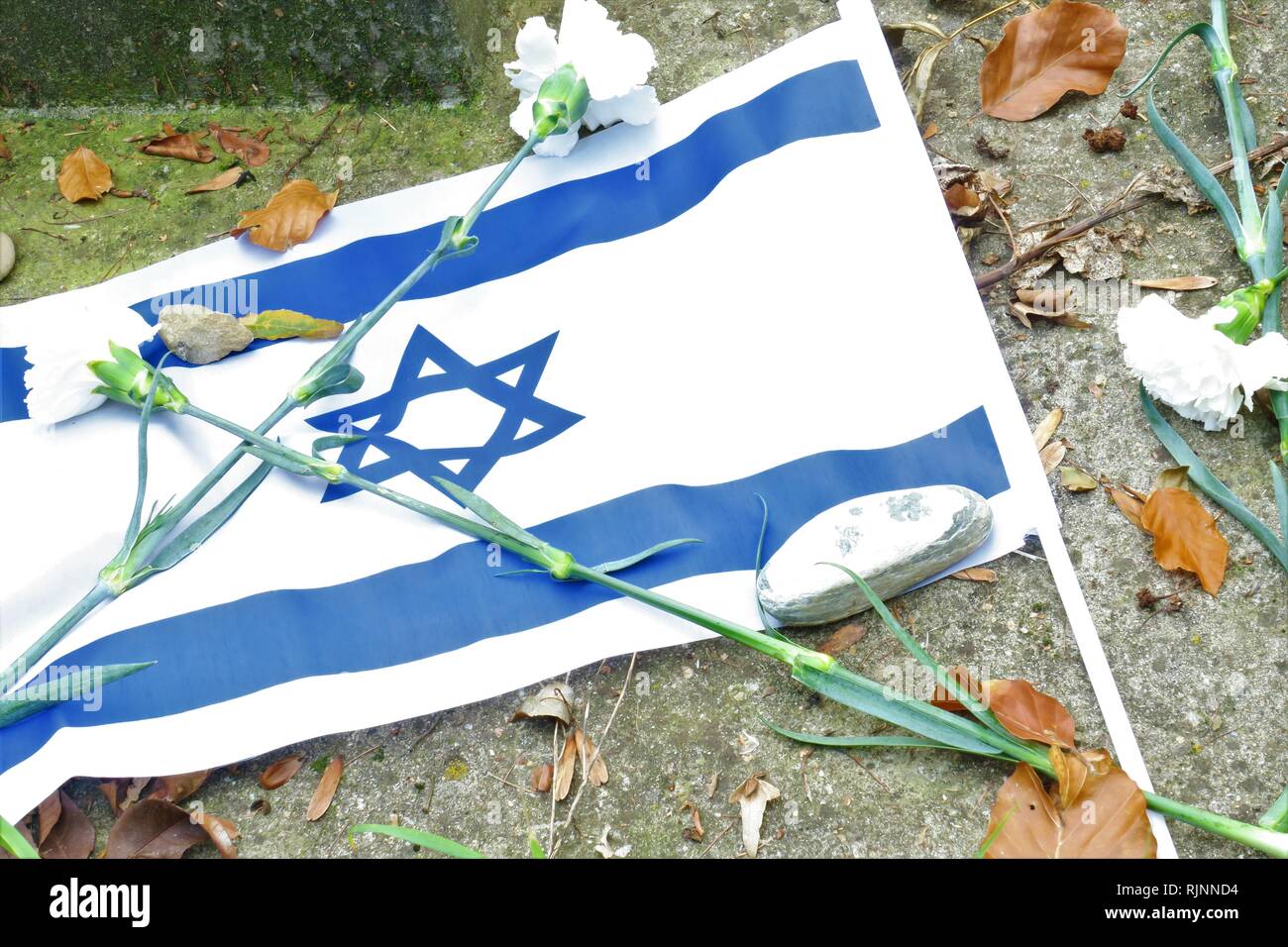 Israel flag laying on a grave with flowers Stock Photo - Alamy