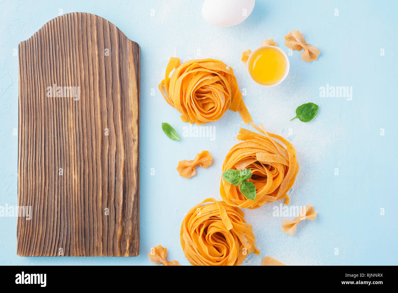 Italian pasta cooking background. Uncooked fettuccine or tagliatelle ...