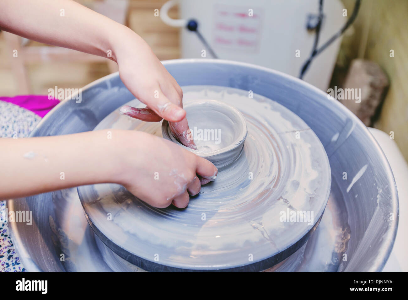 Creative children hands - Making arts - Shaping clay on pottery wheel ...