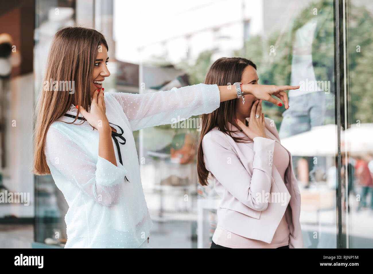 Happy woman pointing finger in the shop window - Image Stock Photo - Alamy