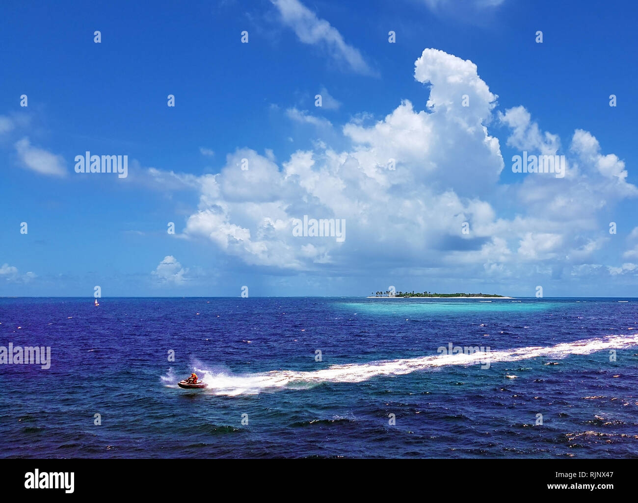 A man is riding a water motorcycle on the blue sea. concept of sport ...