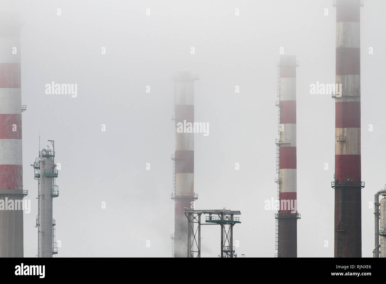 Oil refinery chimneys and towers between fog Stock Photo - Alamy
