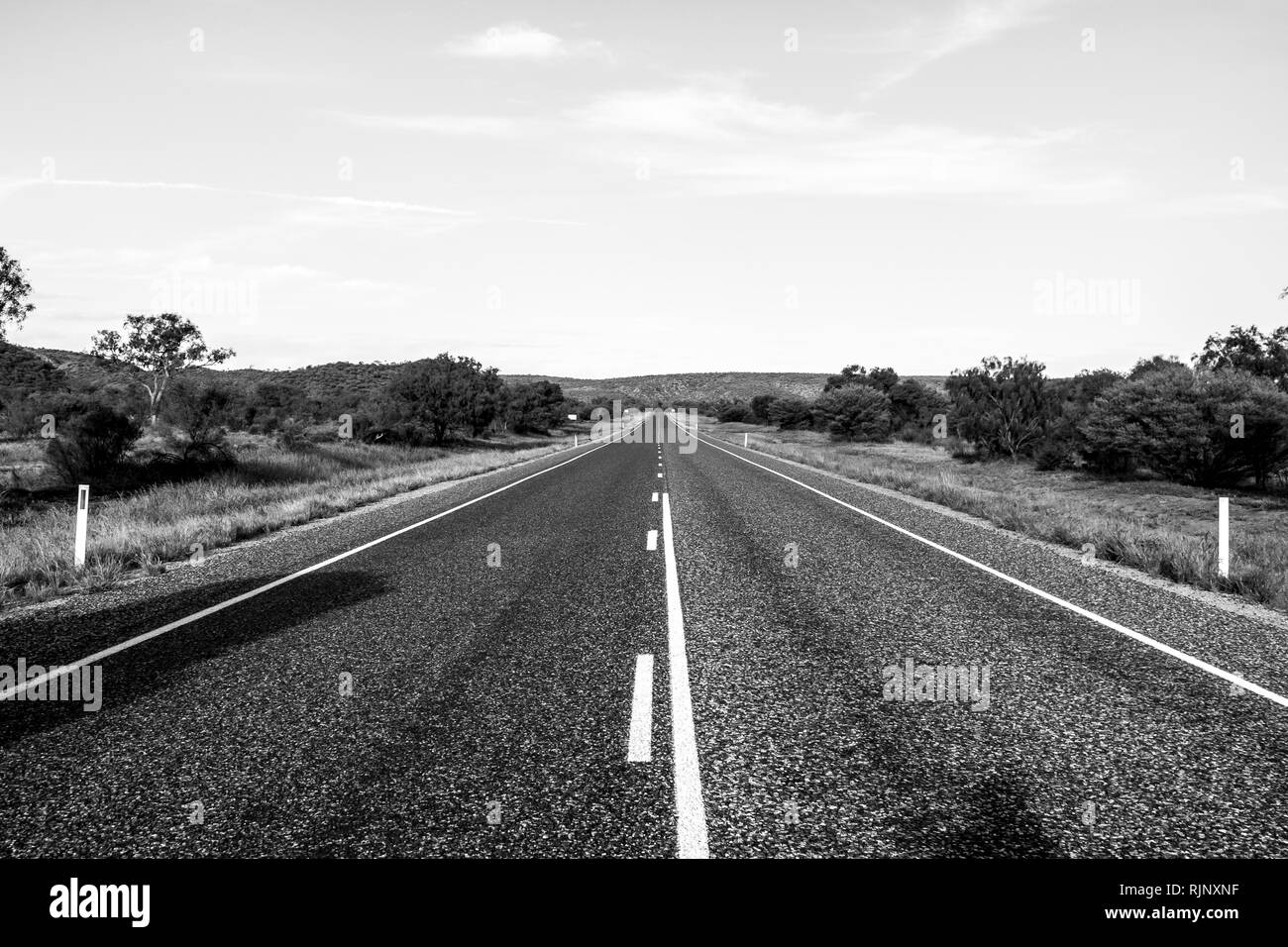 Empty straight asphalt road through Australian outback. Black and white ...