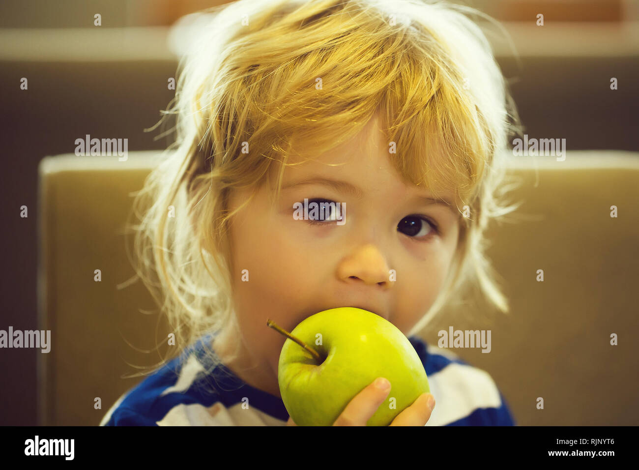 Cute baby boy eating green apple Stock Photo - Alamy