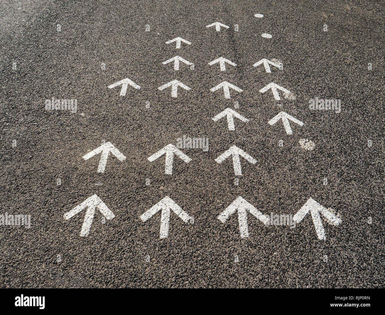 From above shot of white marking of arrow white sign on asphalt ...