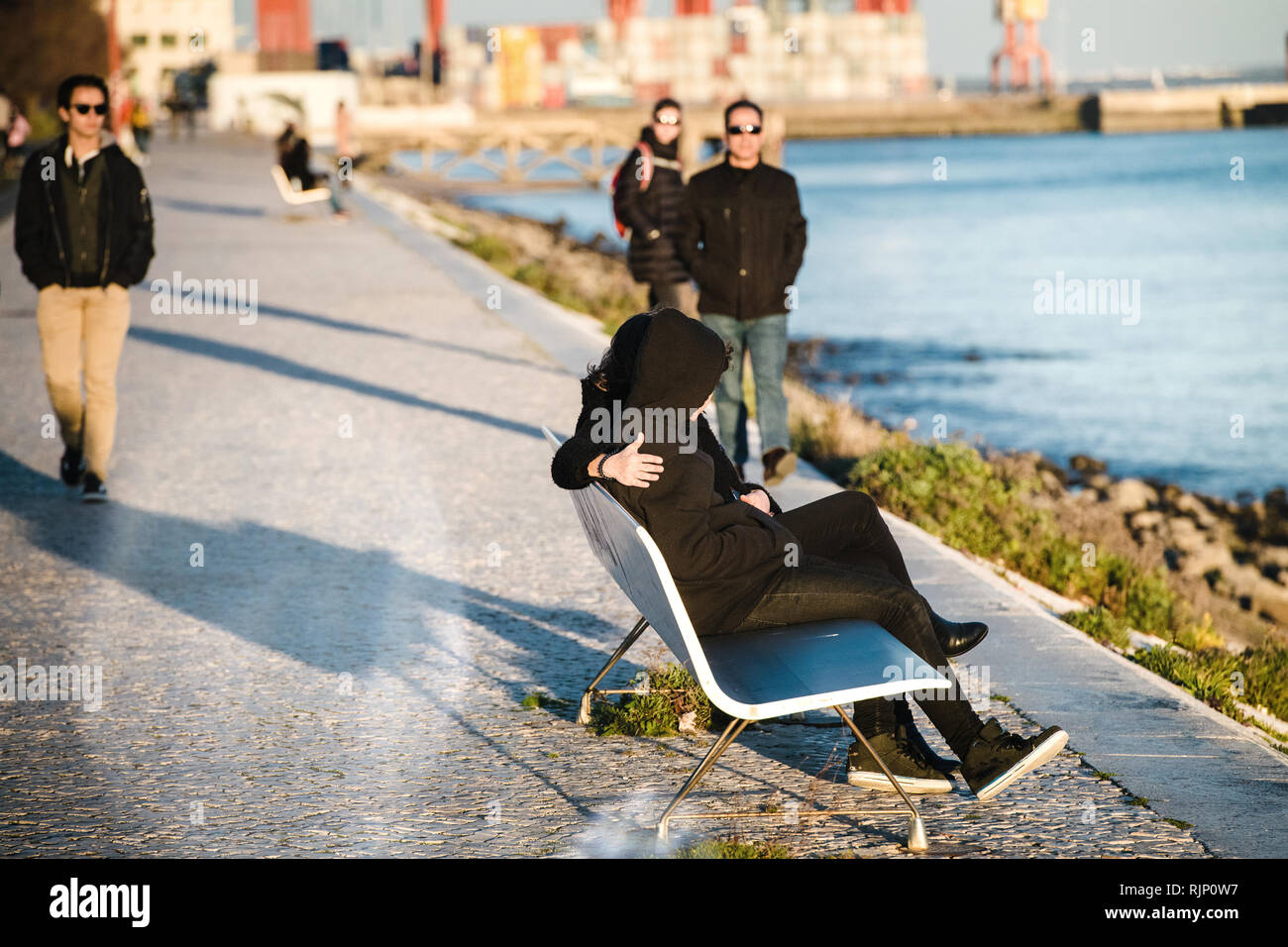 Unrecognizable people walking with side view of couple embracing on ...