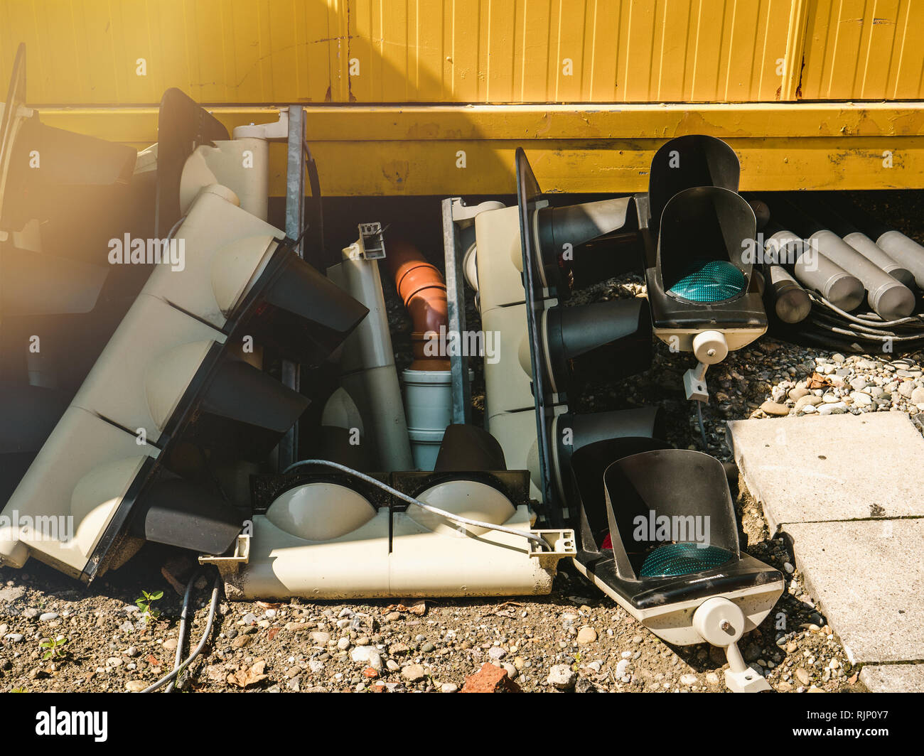 Multiple broken parts of plastic traffic lights in heap on concrete ...