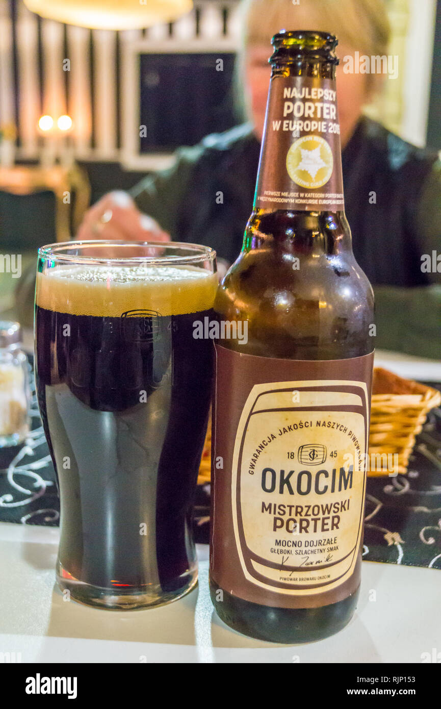 PHOTOGRAPH A bottle and branded glass of Okocim Baltic porter beer ...