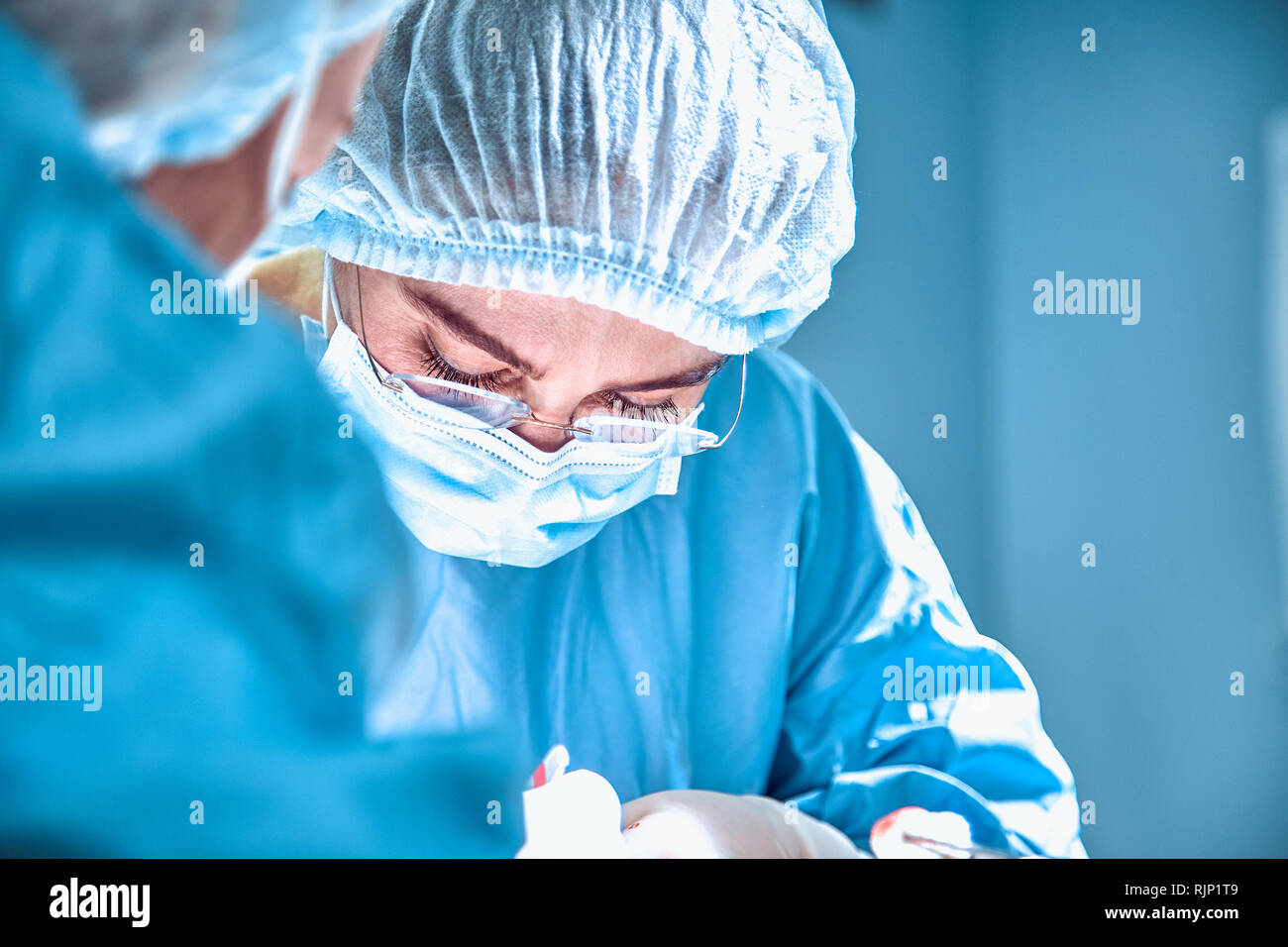 Close up portrait of young female surgeon doctor wearing protective ...