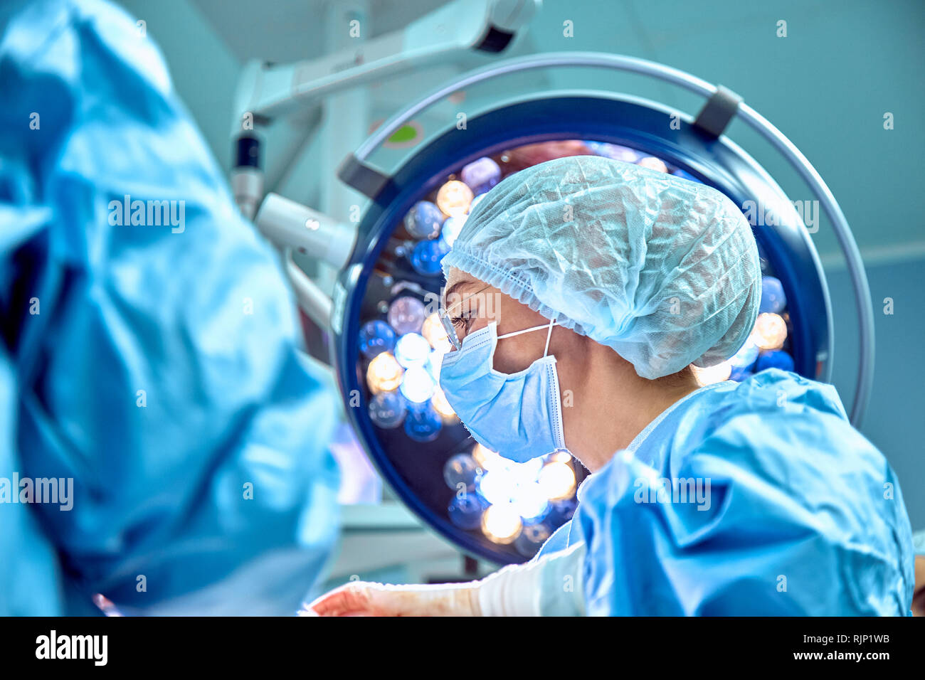 Close up portrait of young female surgeon doctor wearing protective ...