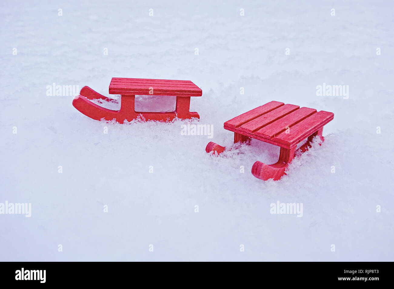 Miniature red sled on white snow with copy space Stock Photo - Alamy