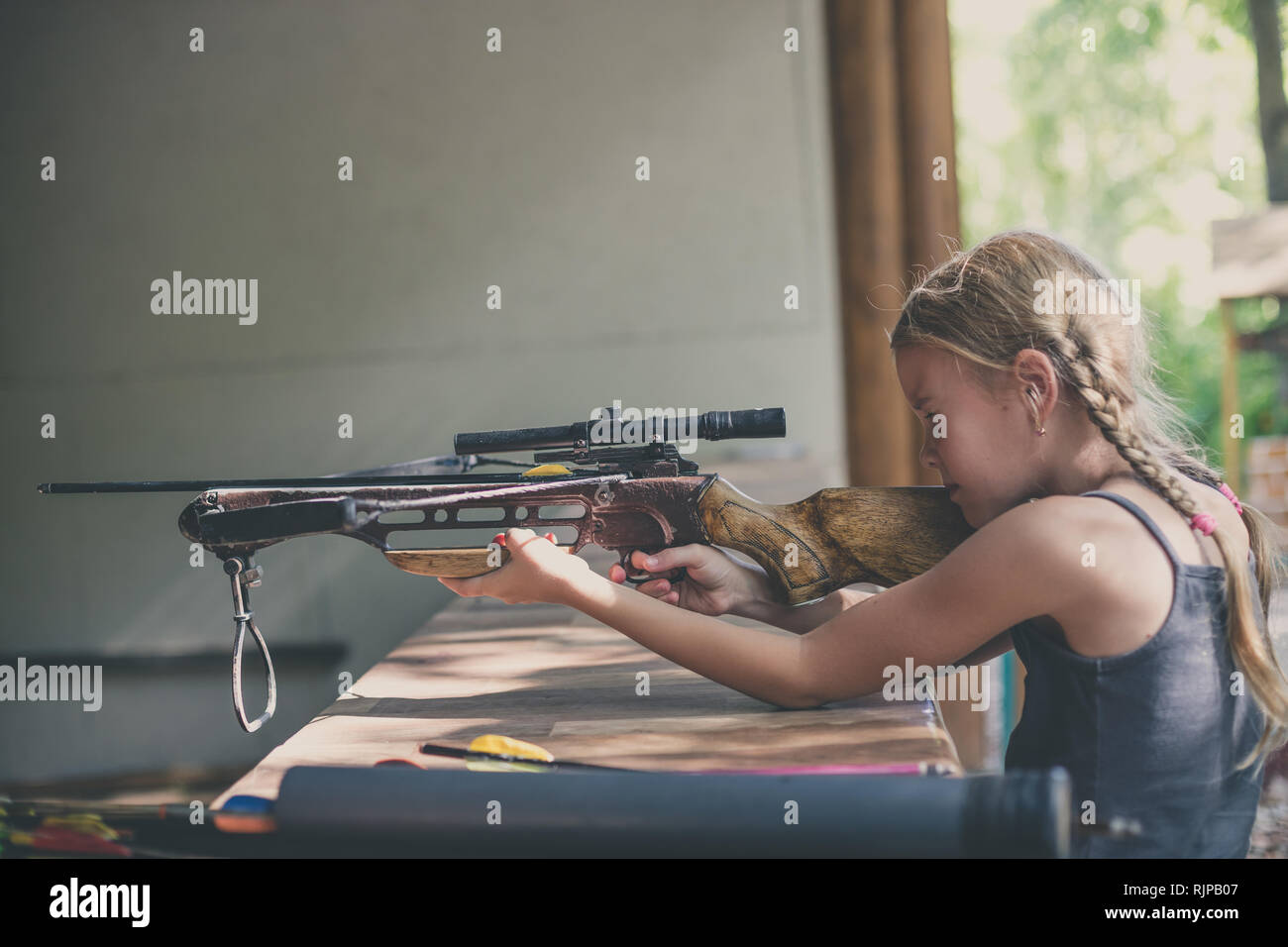 little girl shoots a rifle in the dash of the adventure park. Concept ...
