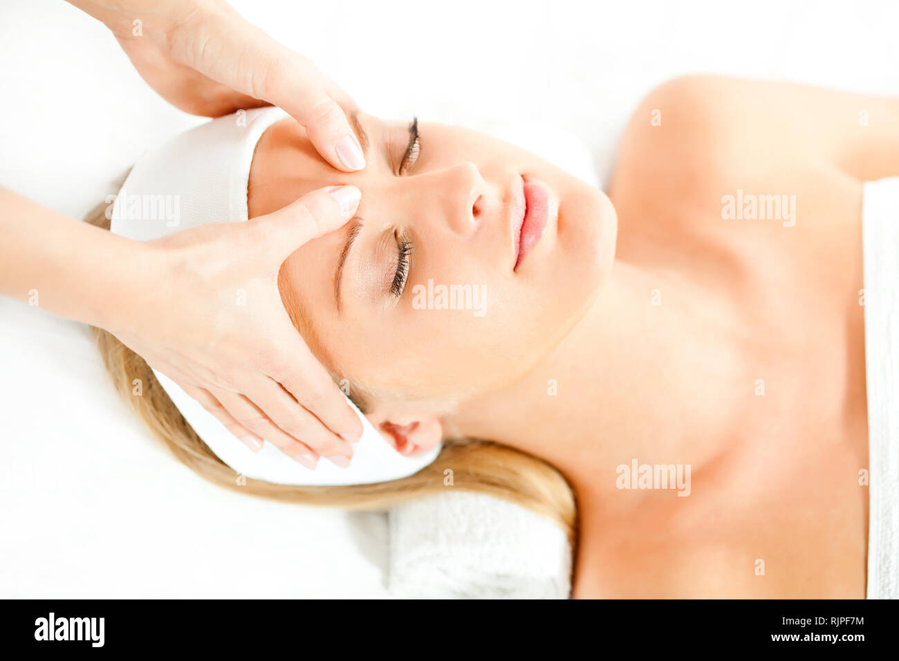 Young woman having forehead massage on spa treatment Stock Photo - Alamy
