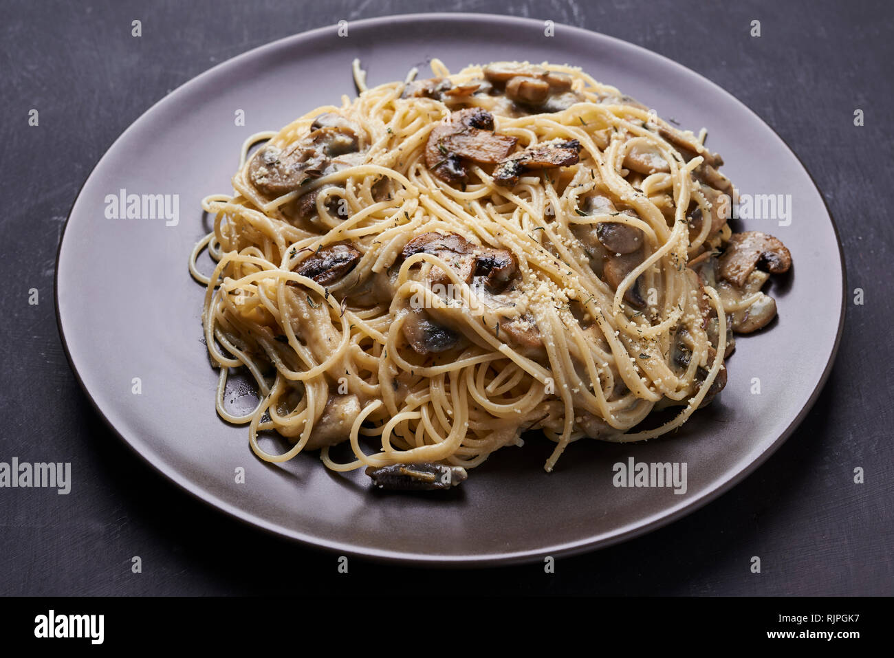 plate of pasta with champignon on dark background Stock Photo - Alamy
