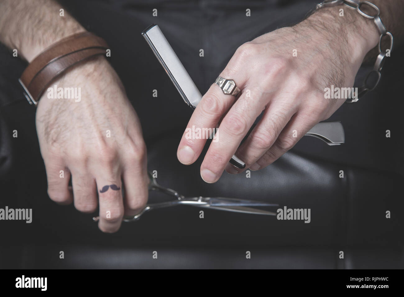 the hands of a barber who hold two of his main tools Stock Photo - Alamy