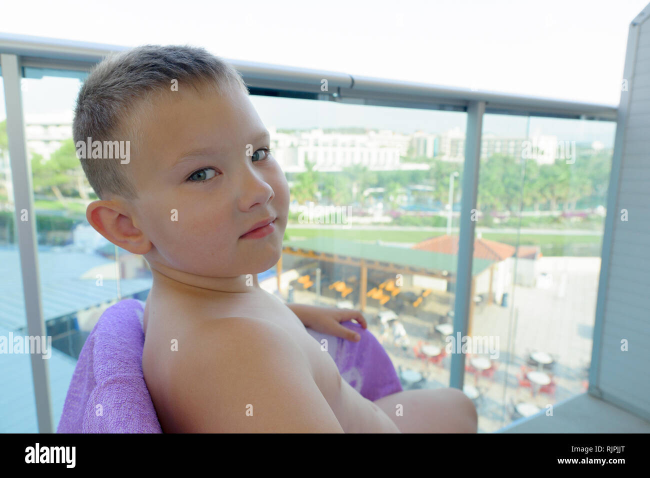 boy is sitting on the balcony enjoying the view of the city Stock Photo ...