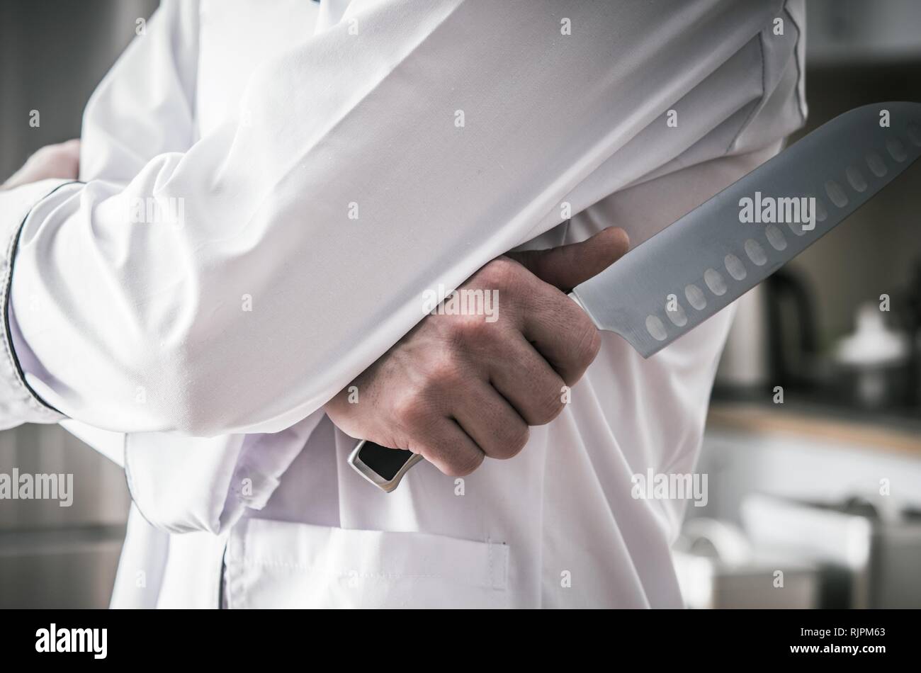 Caucasian Kitchen Chef with Large Knife Closeup Photo. Dinning Industry ...