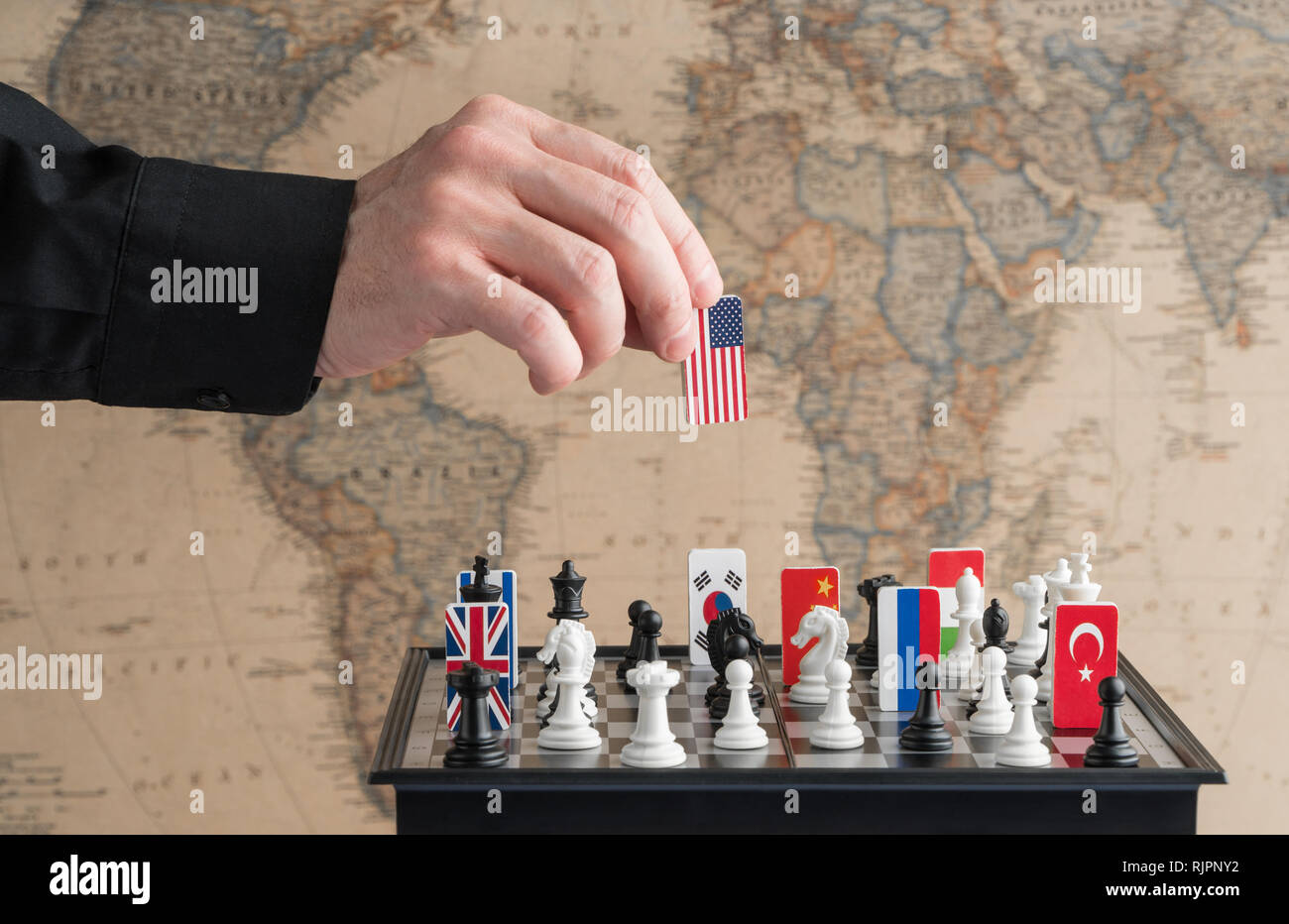 Politician's hand moves a chess piece with a flag. Conceptual photo of ...