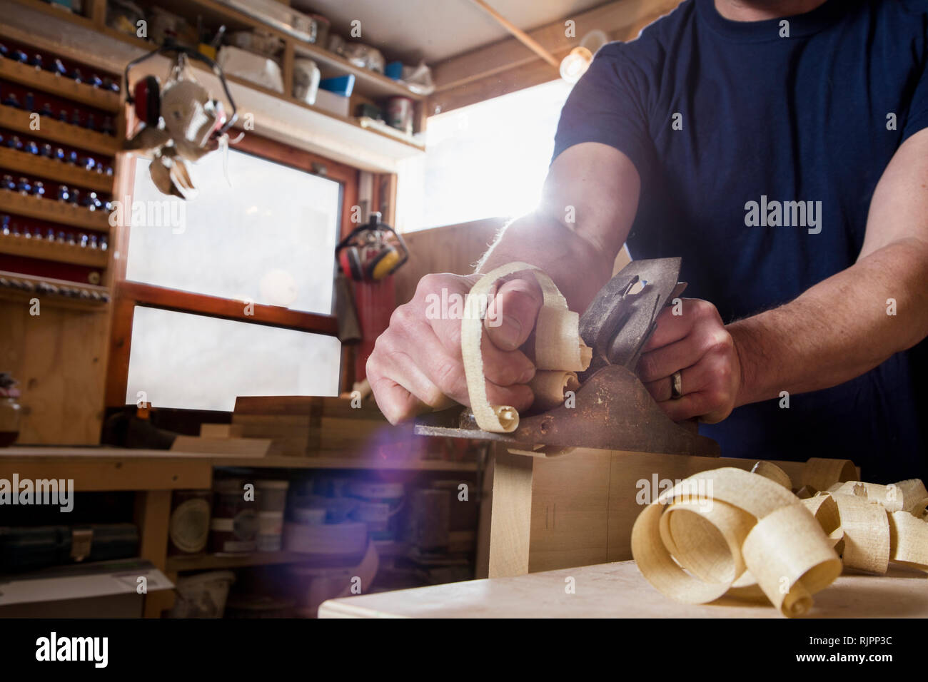 Craftsman using wood plane in workshop Stock Photo - Alamy