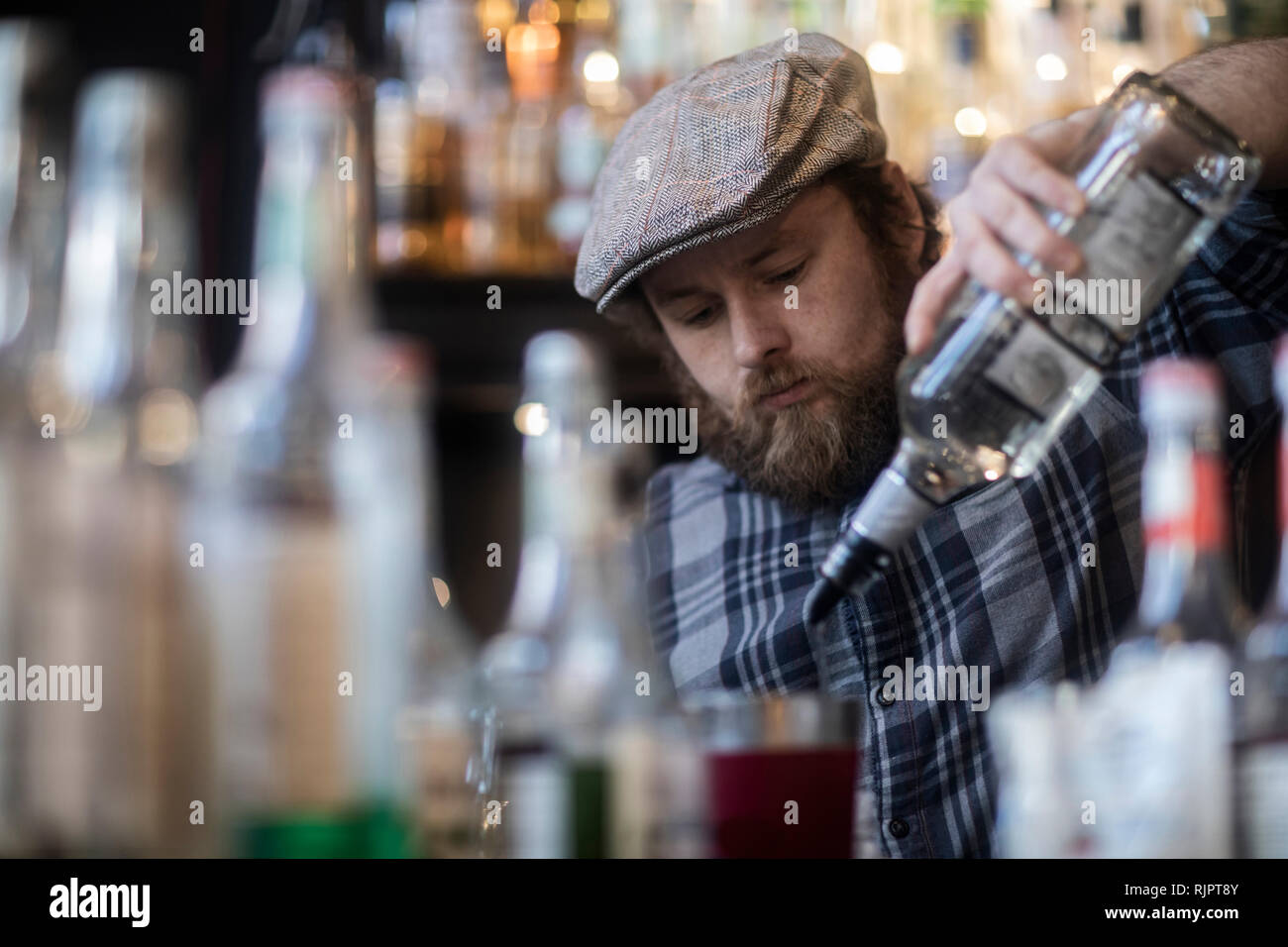 Barman pouring spirit bottle in traditional Irish public house Stock ...