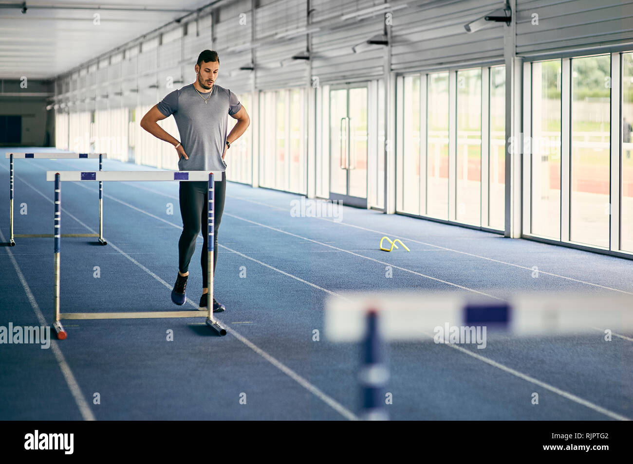 Runner training on indoor running track Stock Photo - Alamy