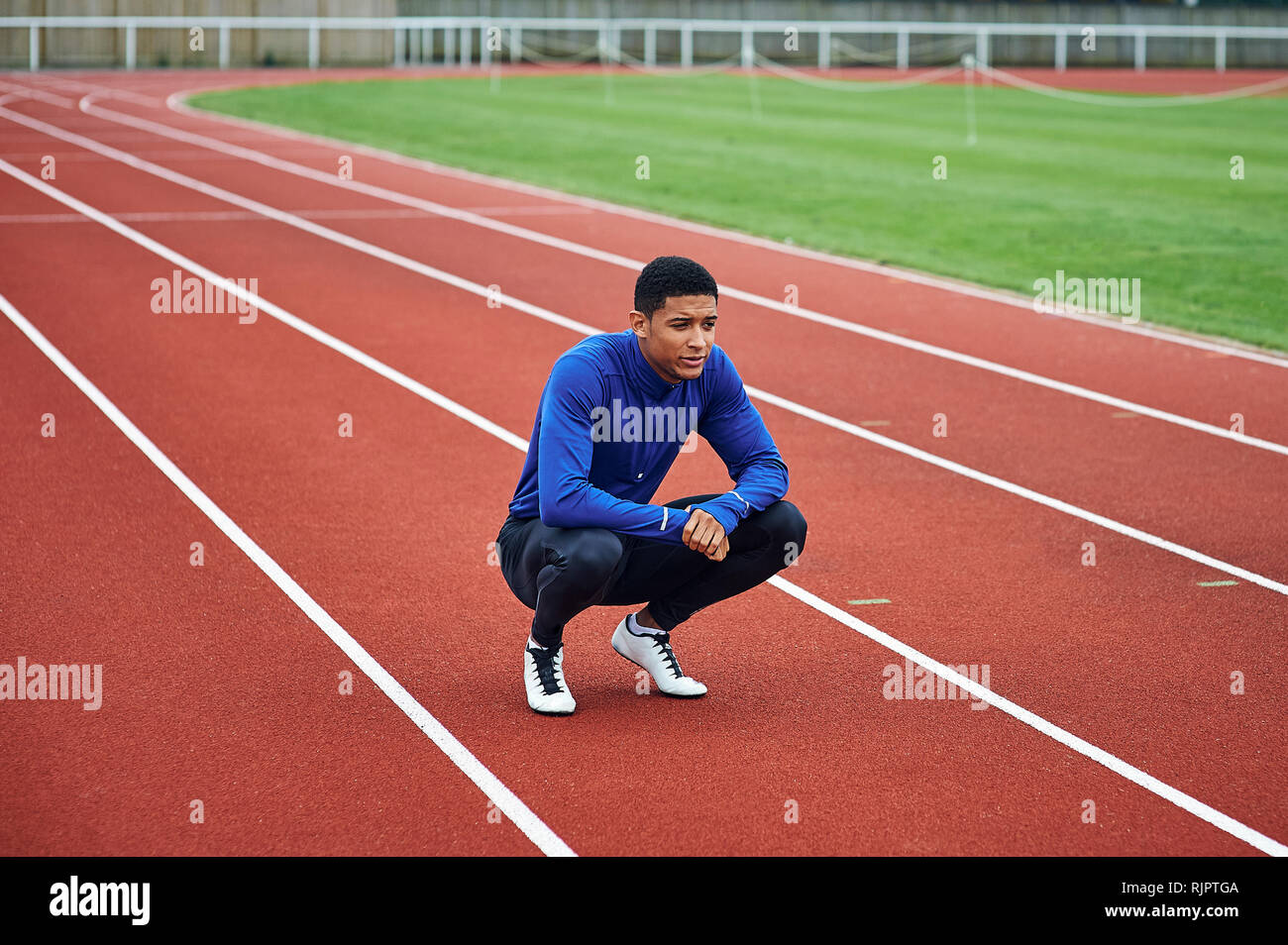 Runner resting on running track Stock Photo - Alamy