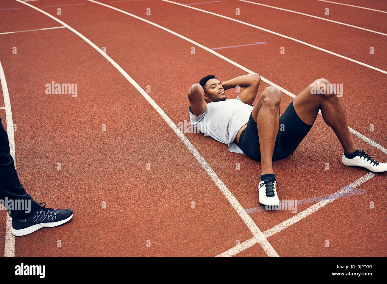 Runners resting on running track Stock Photo - Alamy