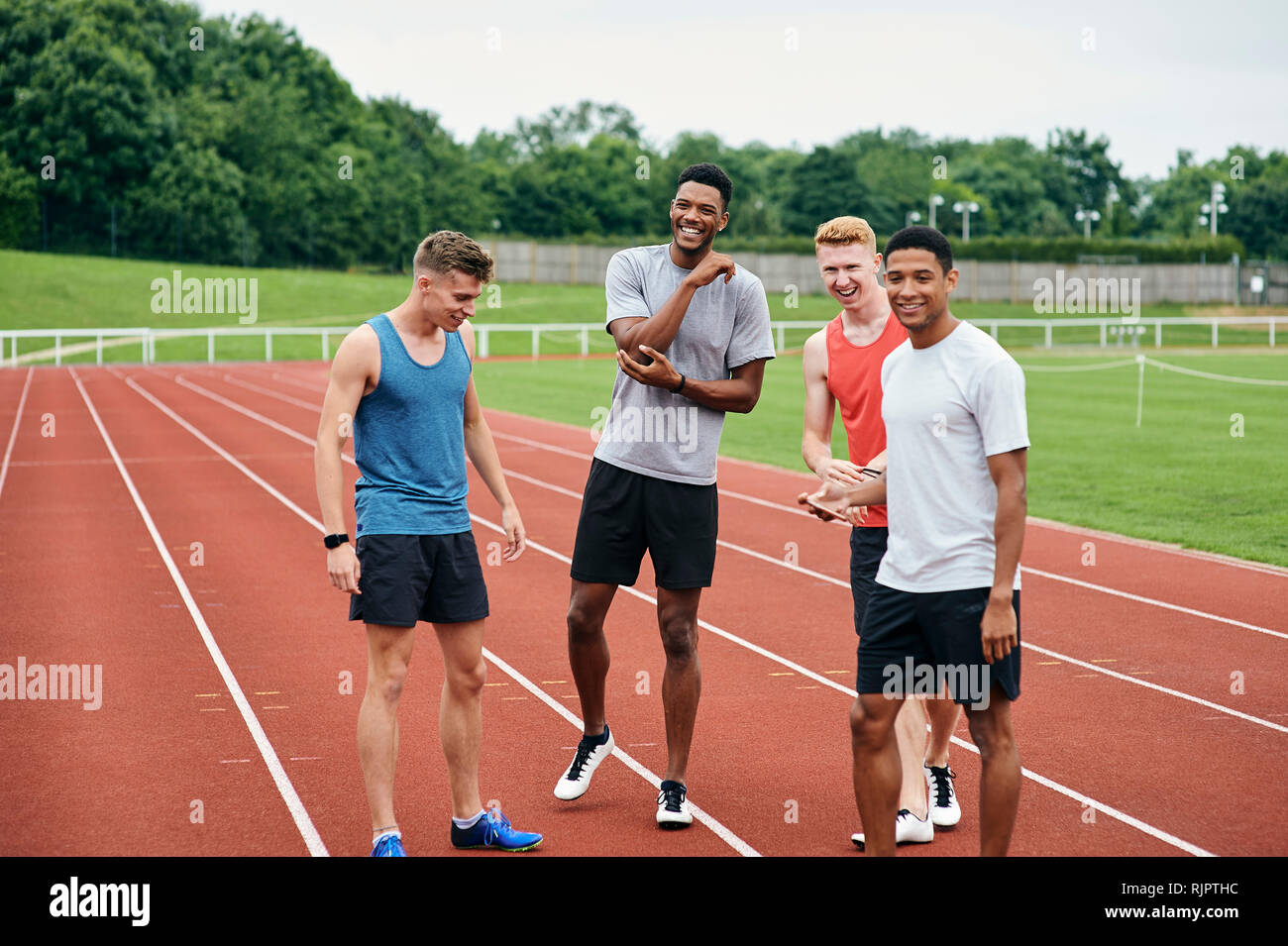 Friends talking on running track Stock Photo - Alamy