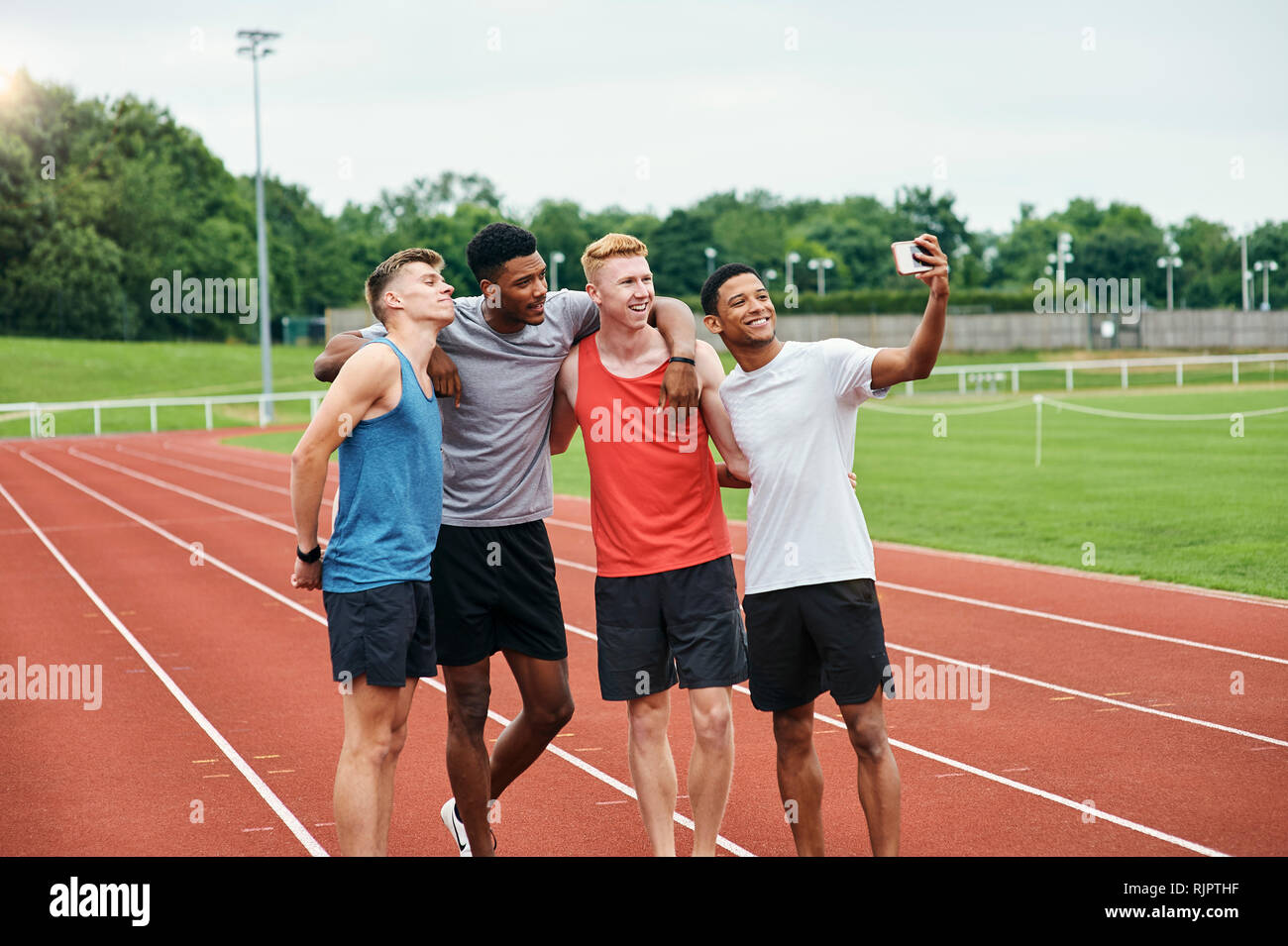Friends taking selfie on running track Stock Photo - Alamy