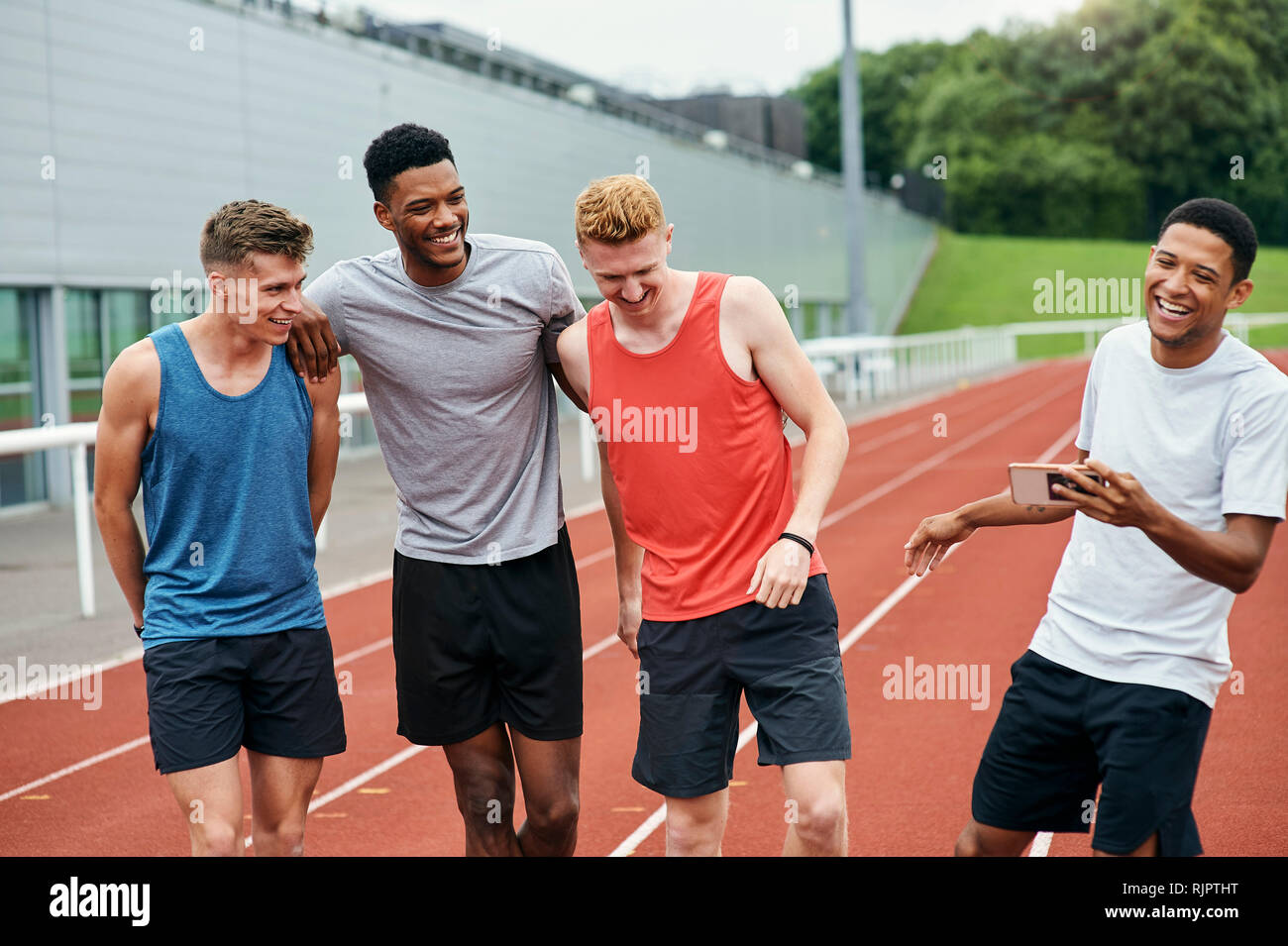 Friends talking on running track Stock Photo - Alamy