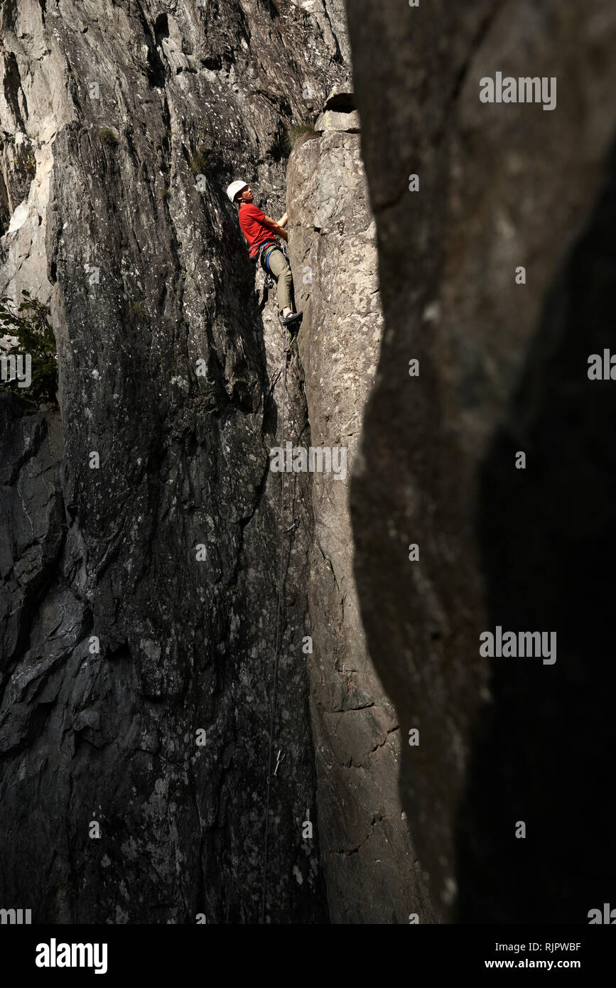 Rock climber scaling cliff face Stock Photo - Alamy