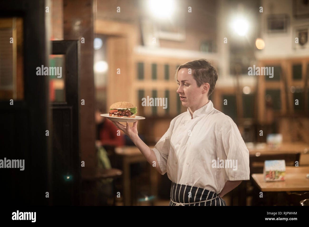 Waitress serving plate of burger in gastro pub Stock Photo - Alamy