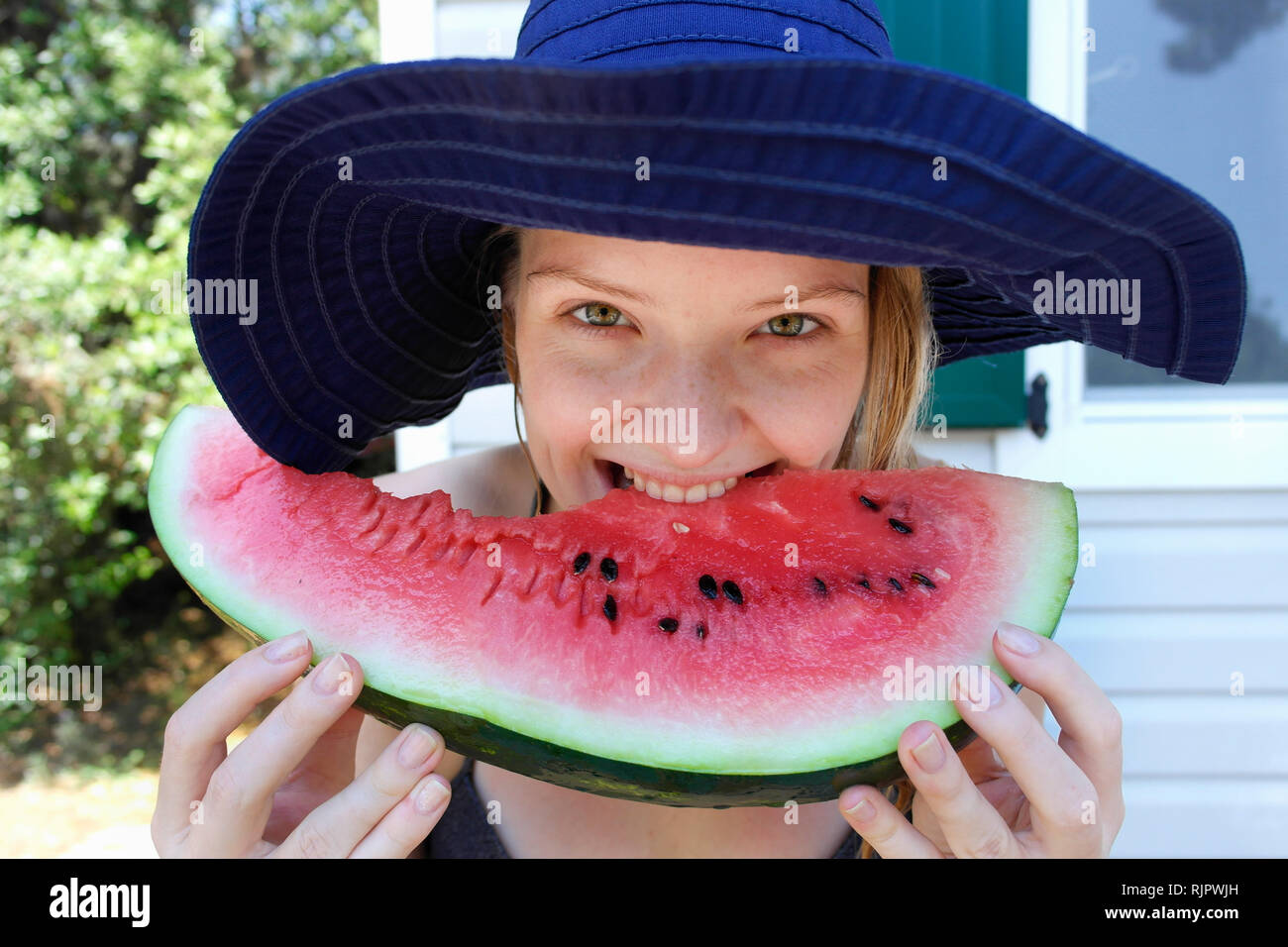 Woman biting into watermelon Stock Photo - Alamy