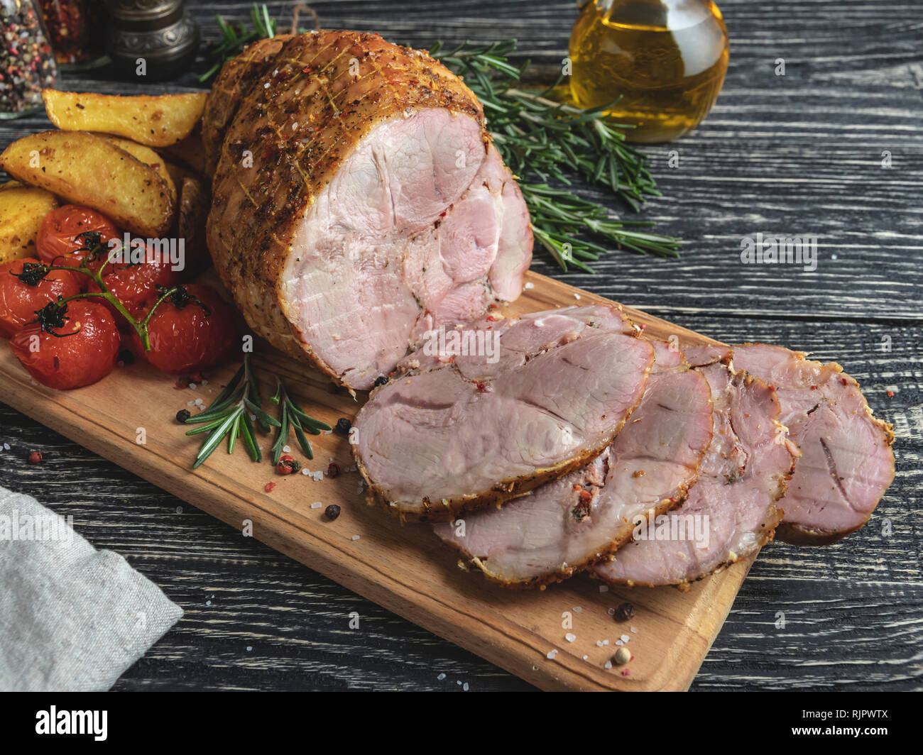 Roasted pork roulade sliced, roll with potato and tomato on cutting ...
