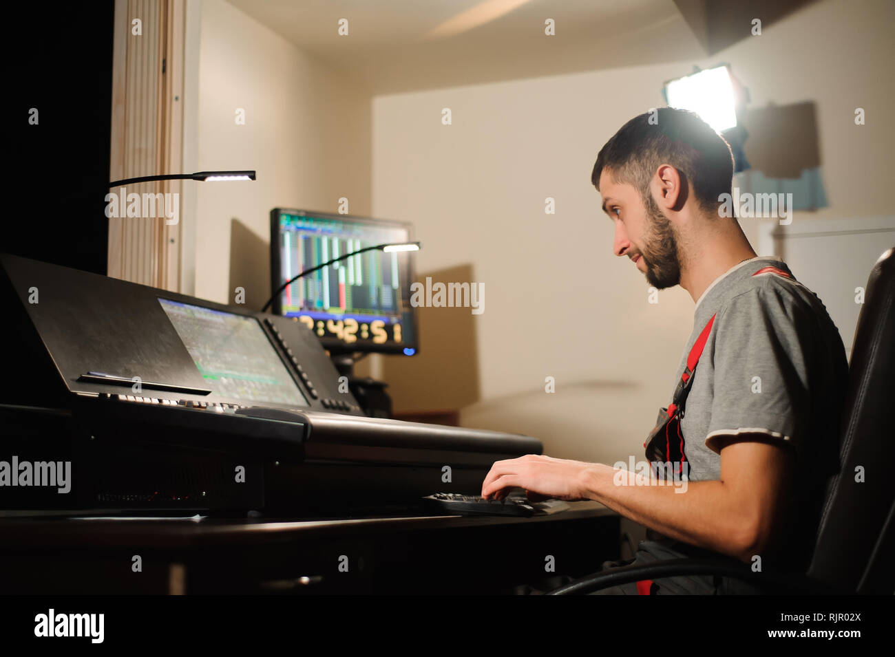 A lighting engineer works with lights technicians control Stock Photo ...