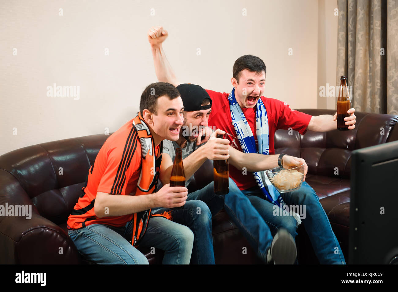 Friends cheering and drinking alcohol while watching soccer matc Stock ...