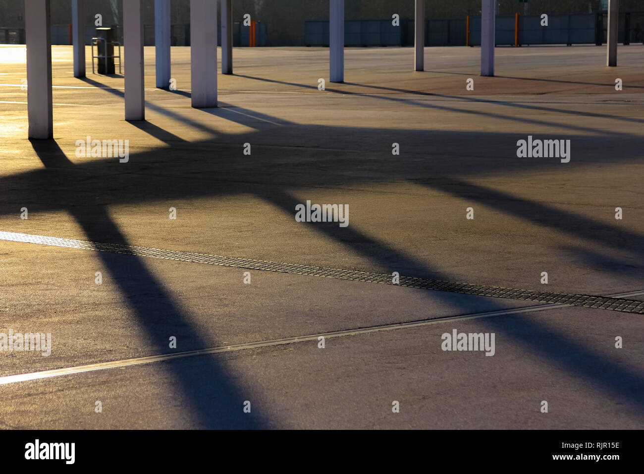Modern architecture shadows on the ground back lit by warm evening sun ...