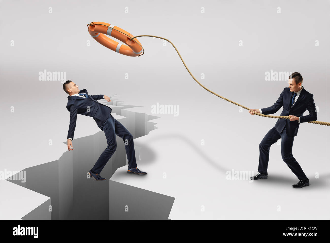 Businessman throwing orange lifebuoy to another businessman who is ...