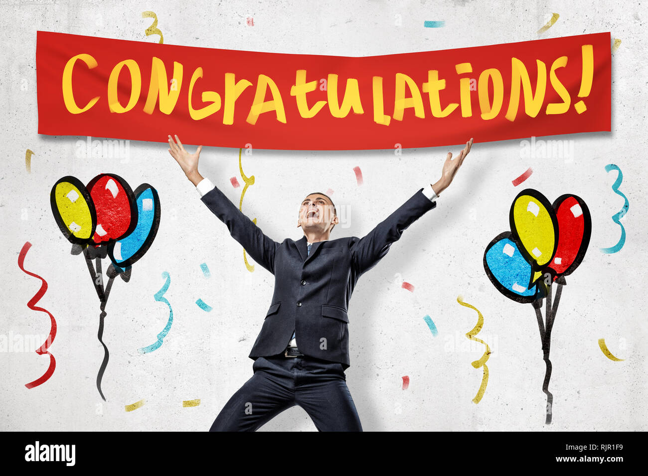 Excited businessman celebrating success with red 'CONGRATULATIONS' sign ...