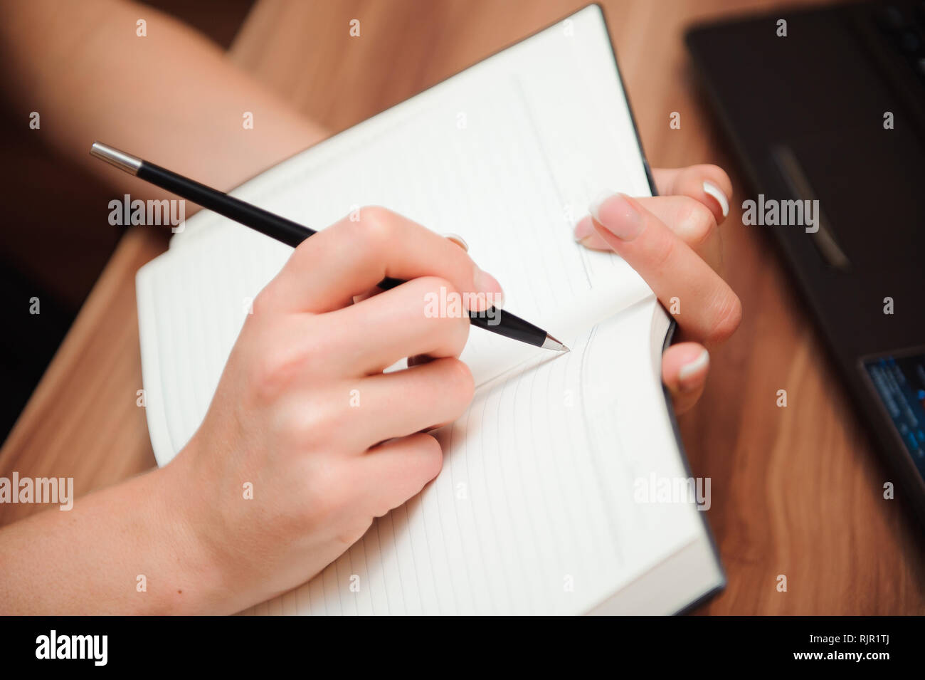 Closeup of a female hand writing on an blank notebook with a pen Stock ...