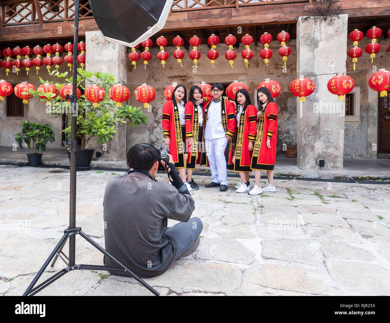 Photographer taking photos of students wearing graduation gowns at ...