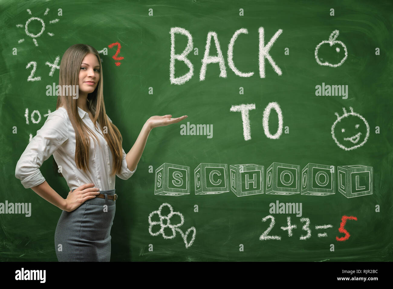 A beautiful businesswoman or a teacher standing half-turn on a school ...