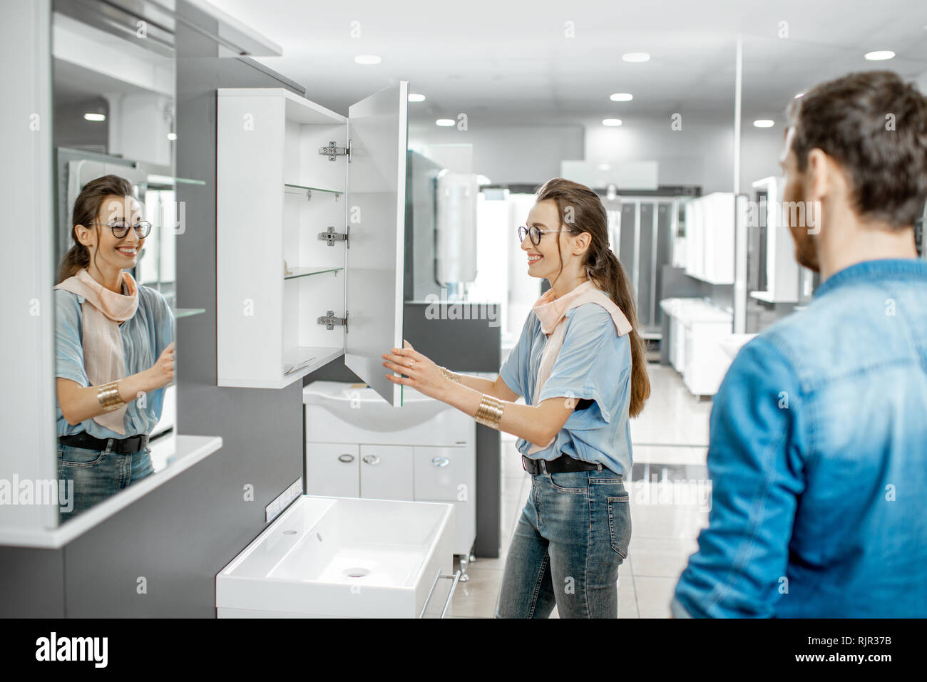 Young Couple Choosing New Bathroom Furniture At The Plumbing Shop With Lots Of Sanitary Goods young-couple-choosing-new-bathroom-furniture-at-the-plumbing-shop-with-lots-of-sanitary-goods