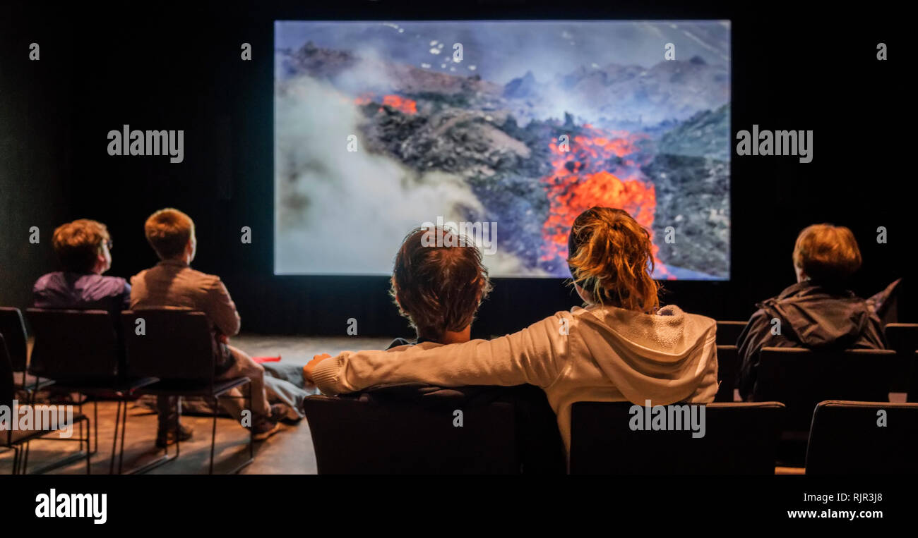People watching volcanic eruption footage, Lava Centre, Hvolsvollur ...